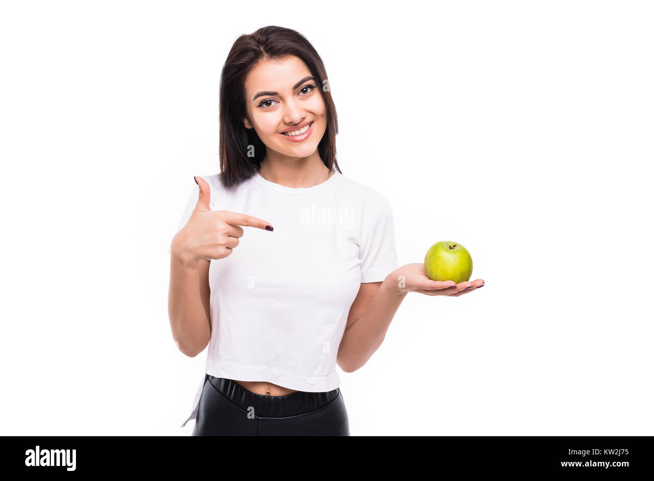 Portrait of a smiling pretty girl holding an apple and pointing finger ...