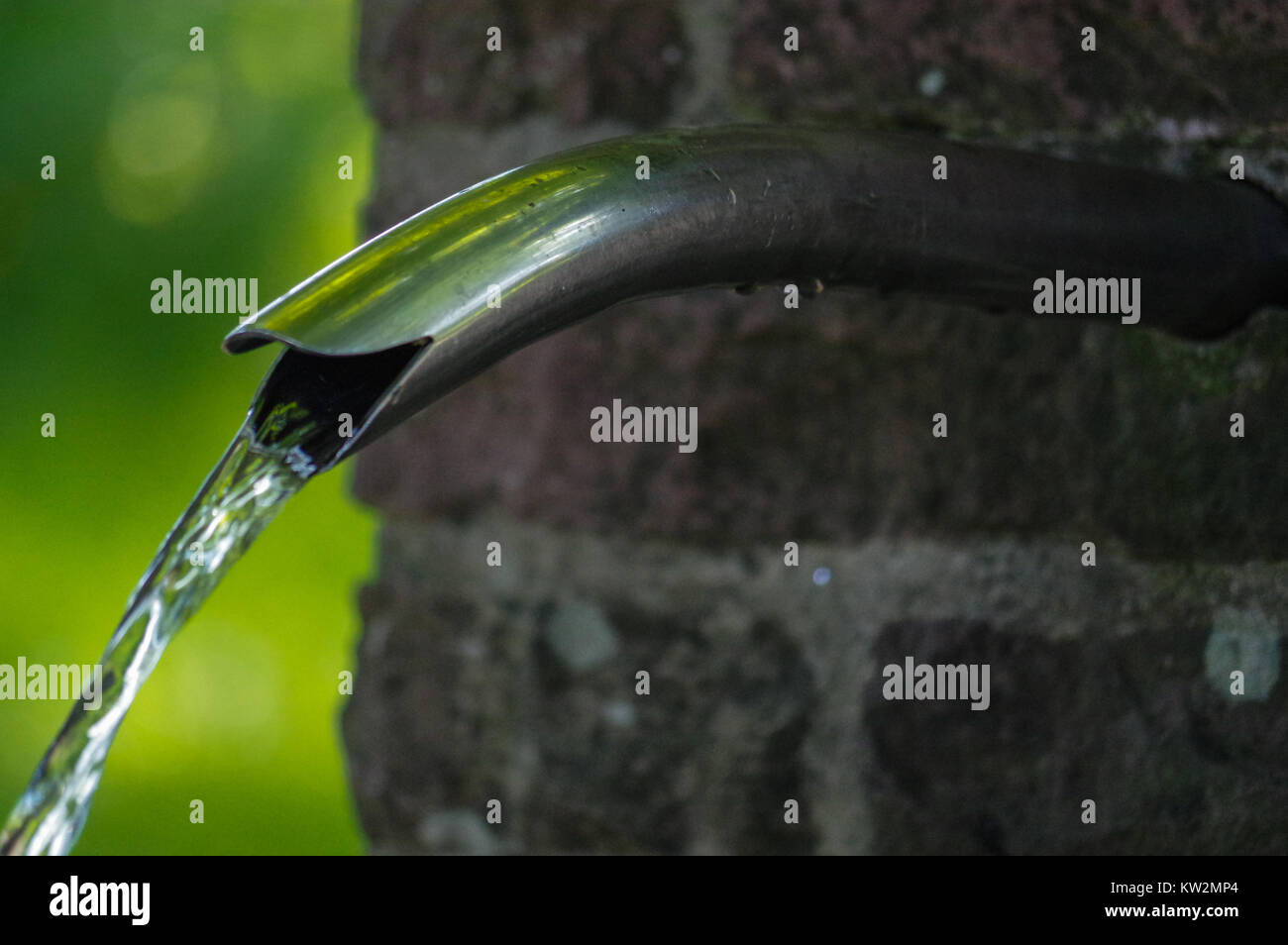 Close up of running water from a tap with a stone background Stock ...