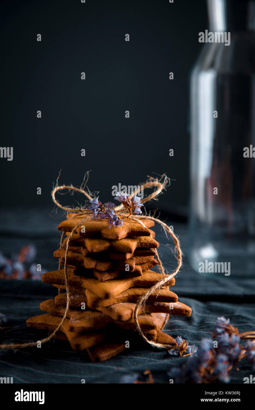Tied stack of star shaped gingerbread cookies and an empty bottle of ...
