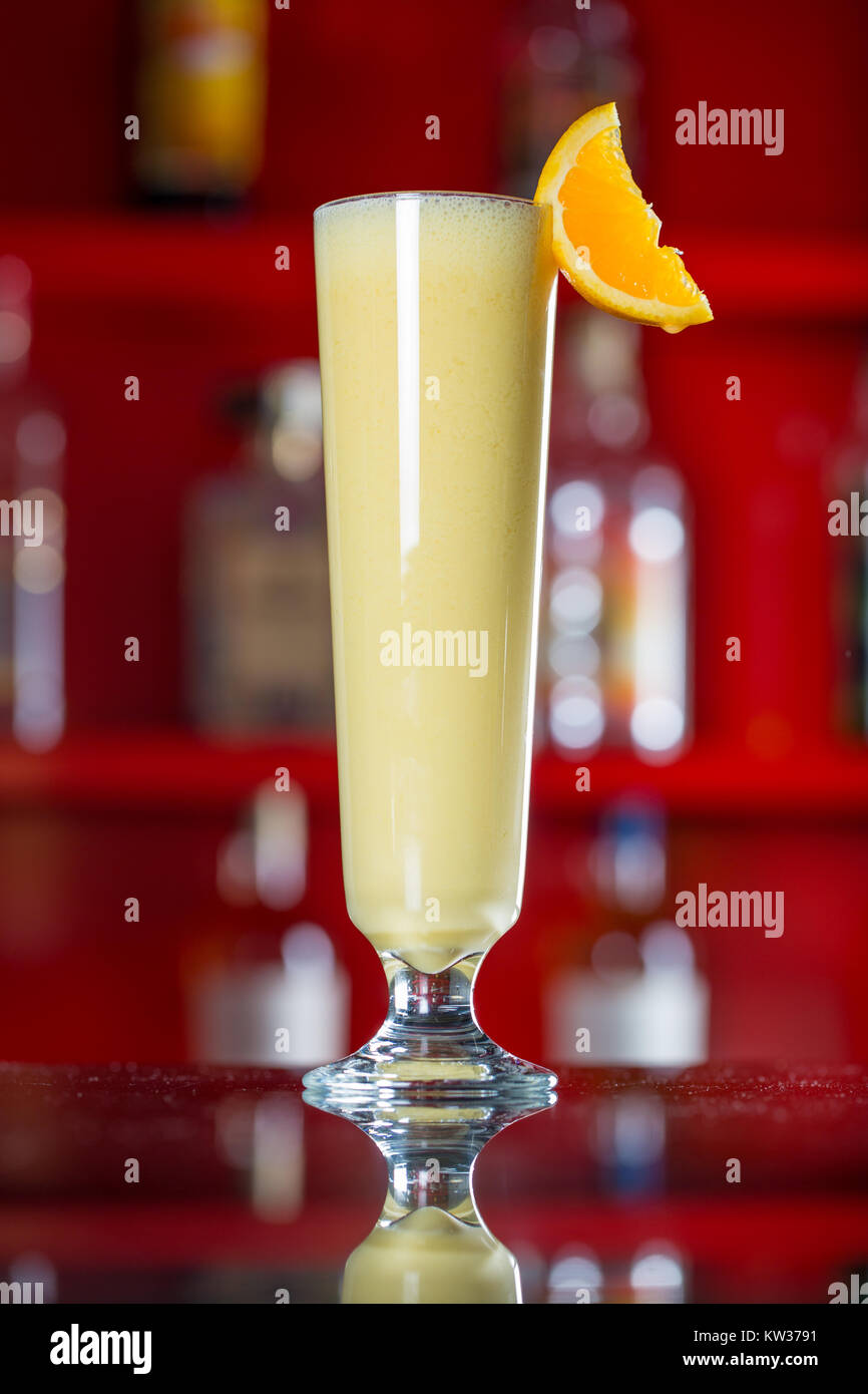 Glass of yellow smoothie on a bar background Stock Photo - Alamy
