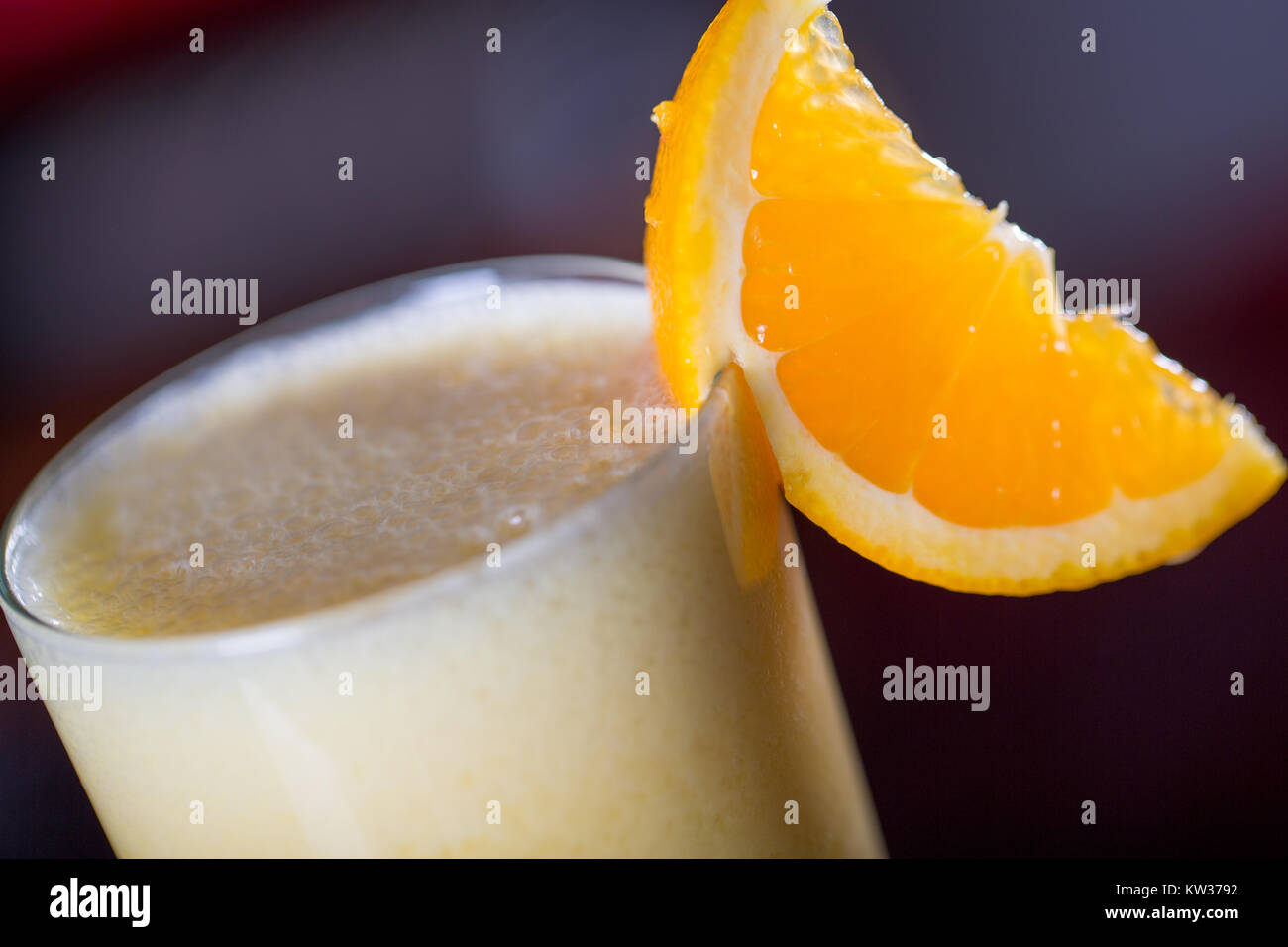 Glass of yellow smoothie on a bar background Stock Photo - Alamy