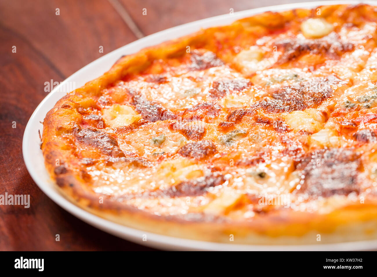Four cheese pizza top view with wooden table Stock Photo - Alamy
