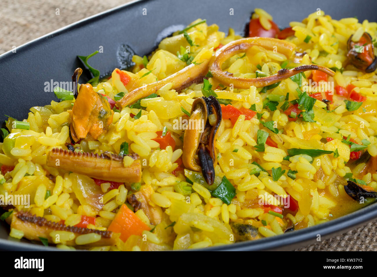 Close up of seafood risotto on a black plate Stock Photo - Alamy