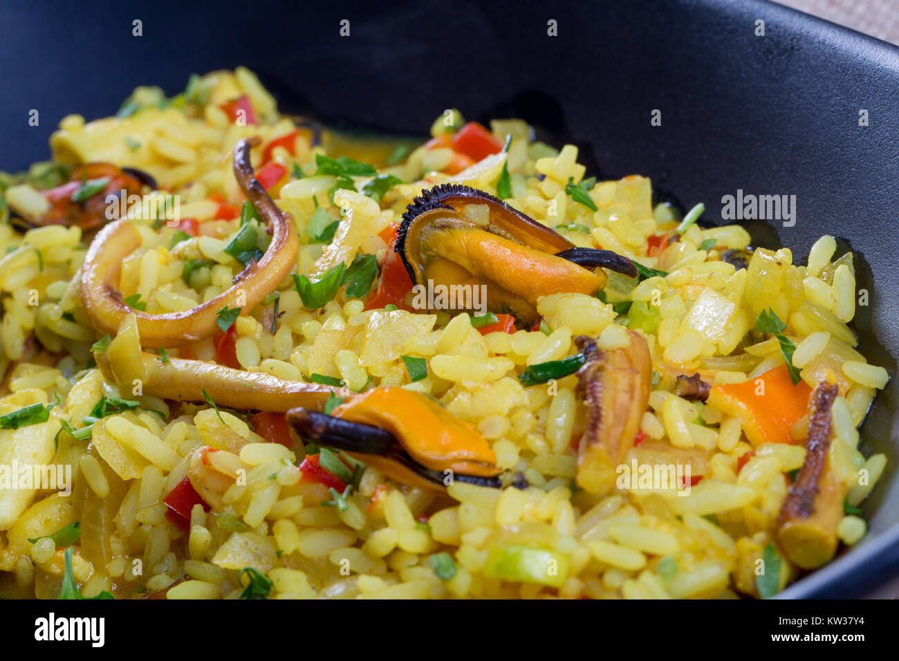 Close up of seafood risotto on a black plate Stock Photo - Alamy