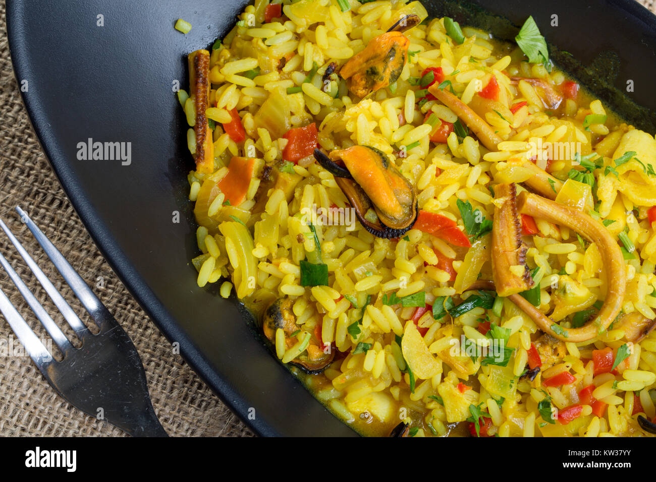 Close up of seafood risotto on a black plate Stock Photo - Alamy