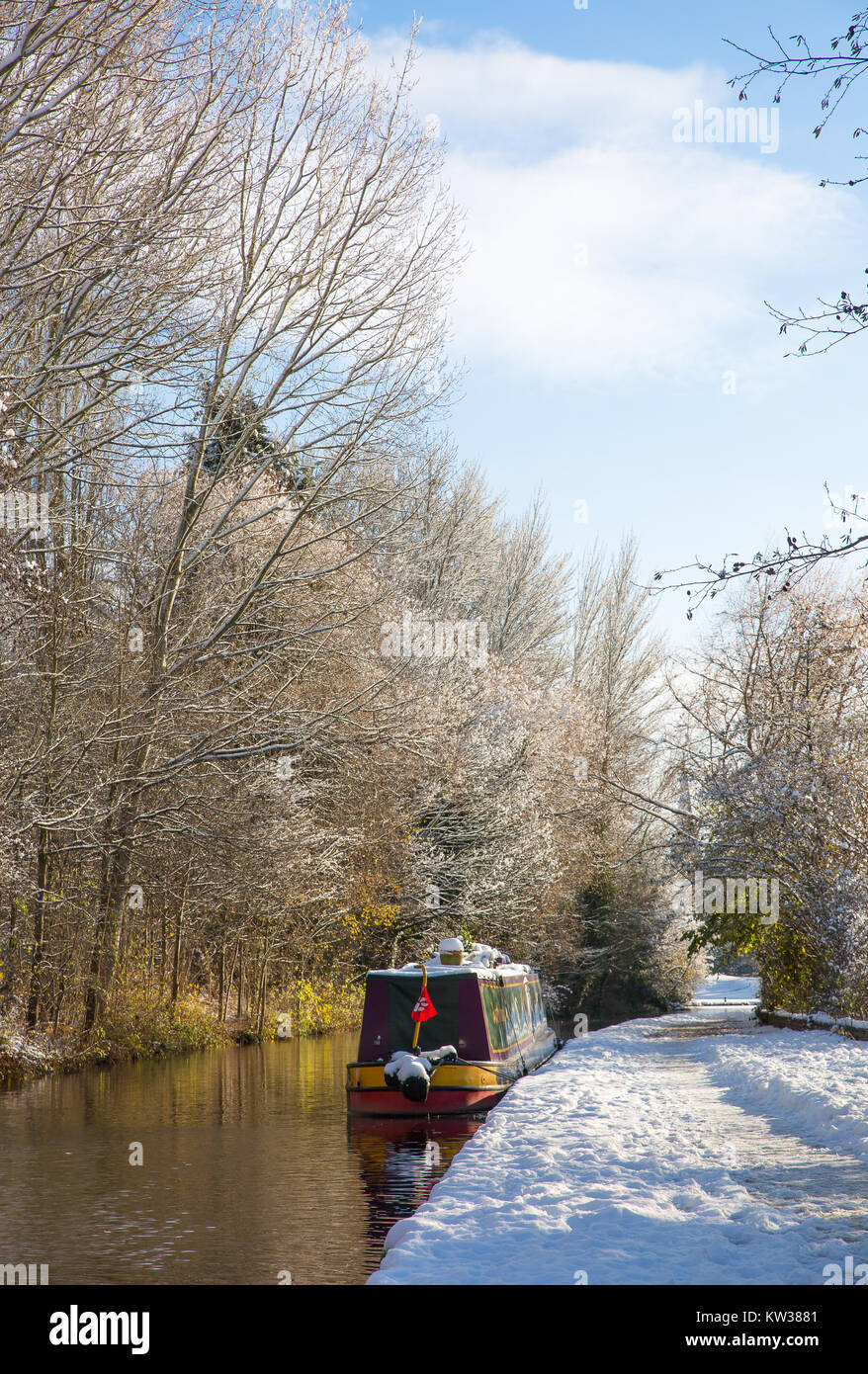 Winter canal scene, UK. Colourful canal boat moored alongside snow ...