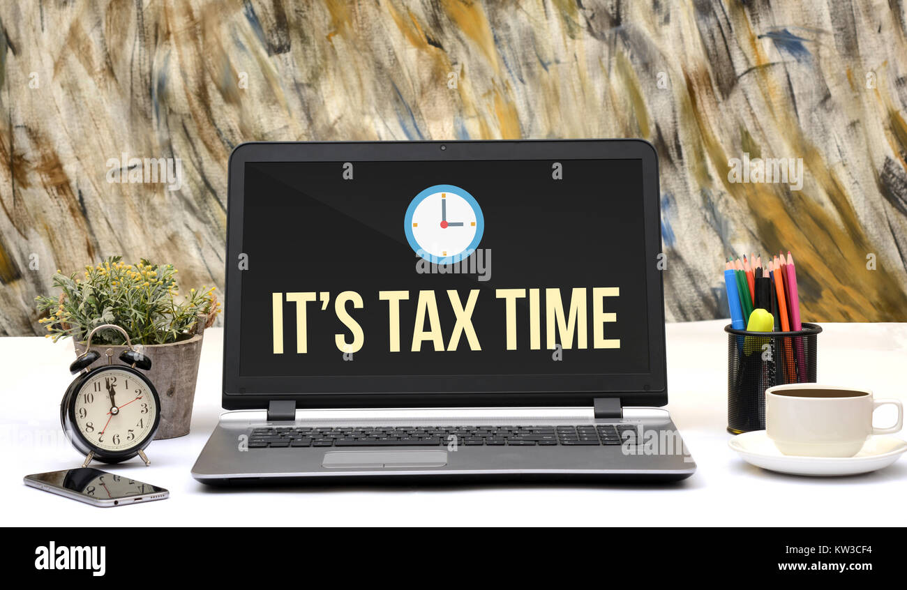 It is Tax Time with clock icon on laptop screen Stock Photo - Alamy
