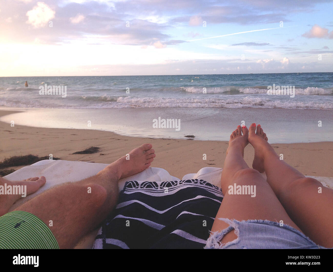 Couple sunbathing and relaxing on a beach Stock Photo - Alamy