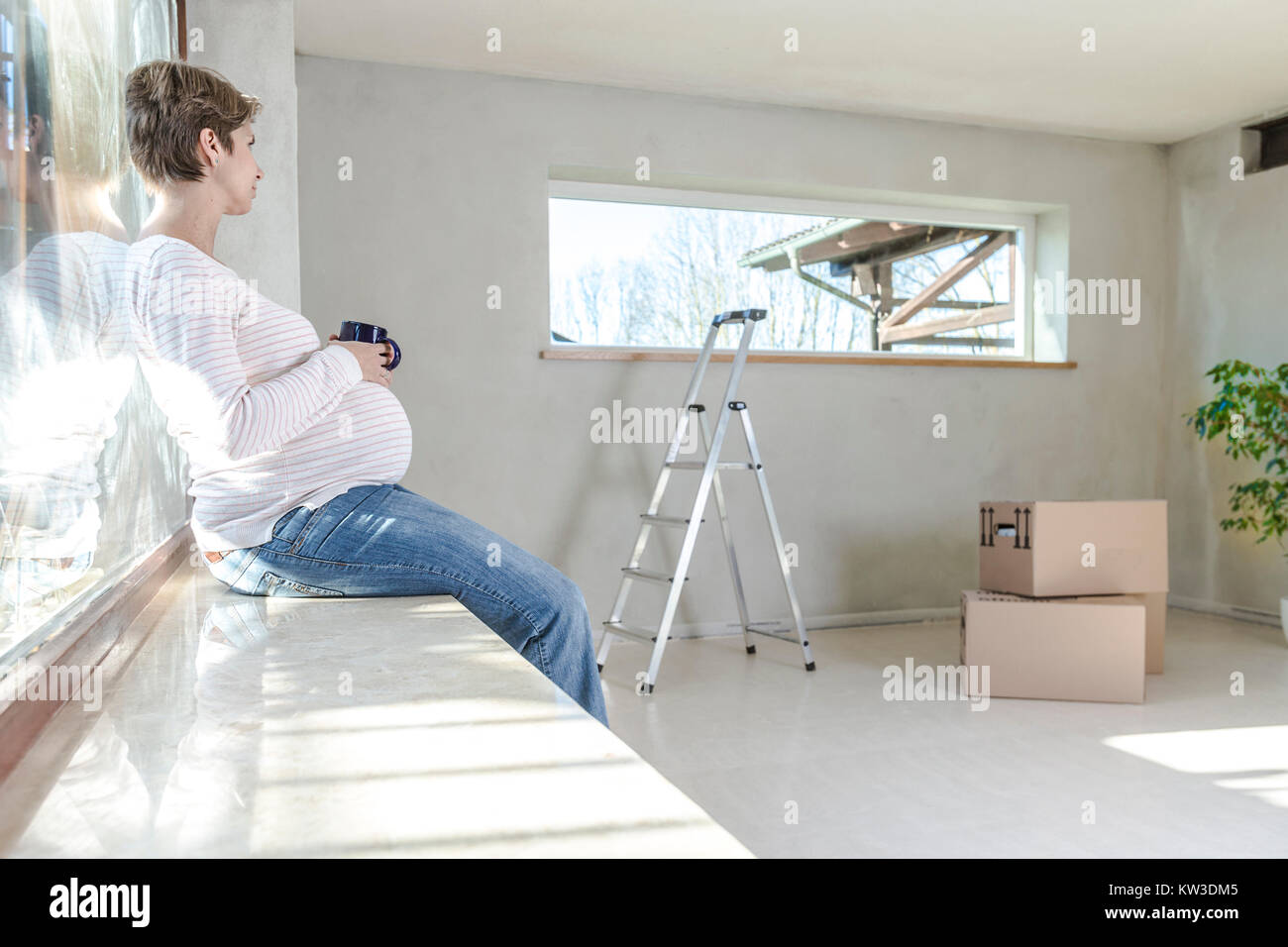 Expecting woman relaxing on building site during relocation Stock Photo ...