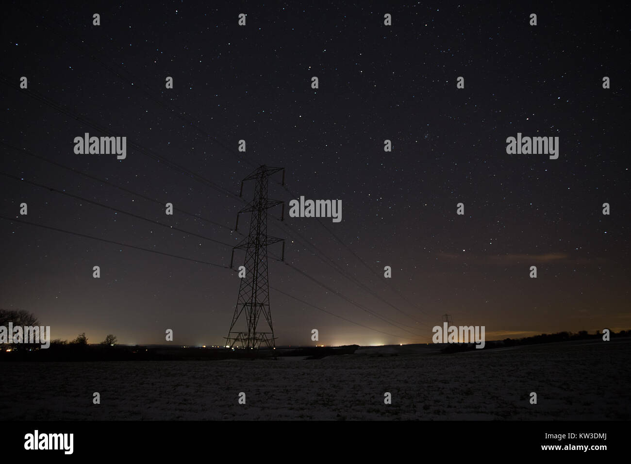 Starry night over pylons in snowy fields near Hannington Hampshire ...