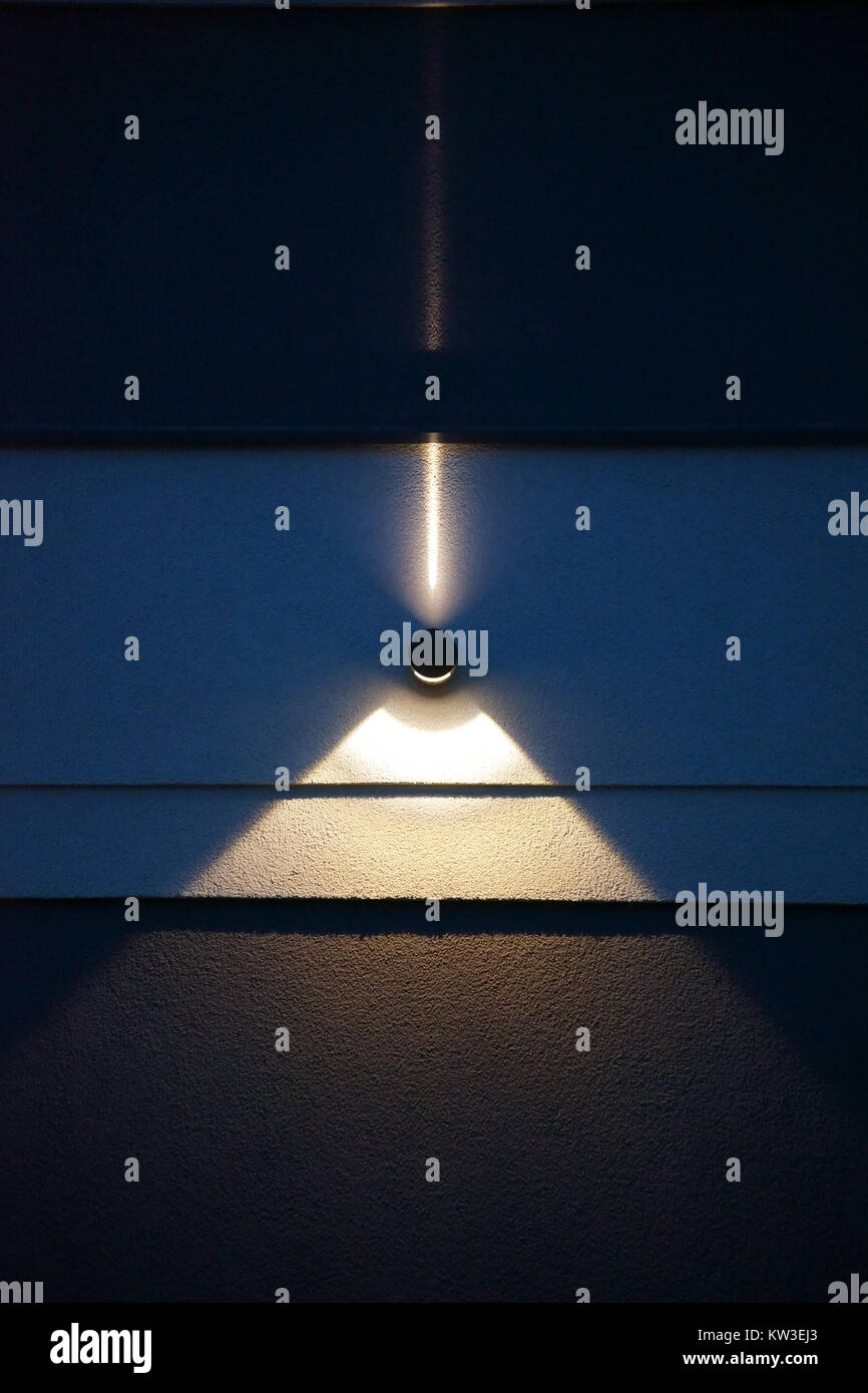 The close-up of a wall spotlight on a smooth concrete wall which ...