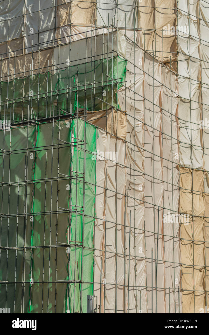 A large building under construction, covered in colorful material Stock ...