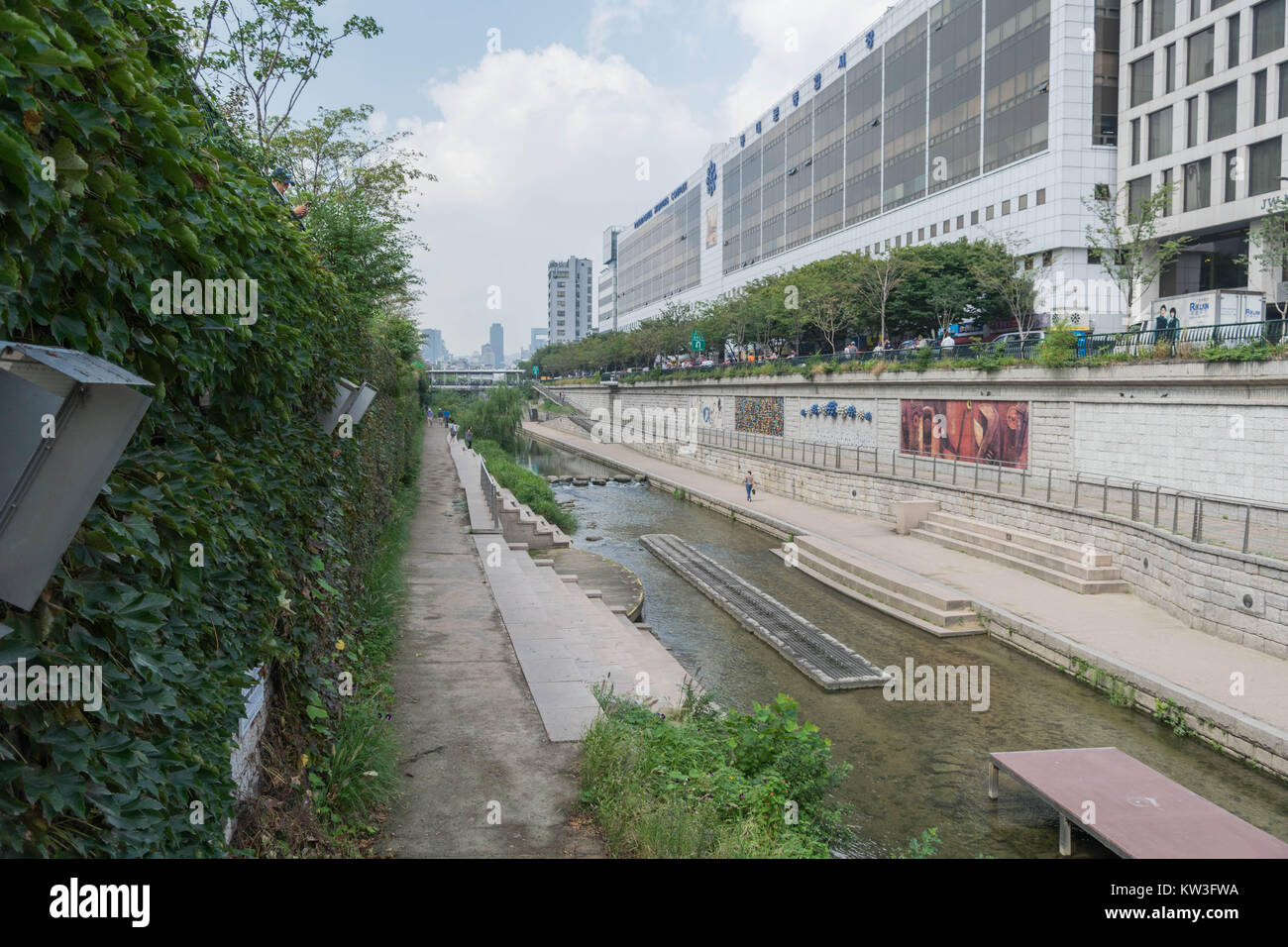 Lengthy view of the Cheonggyecheon stream and walkways going in each ...
