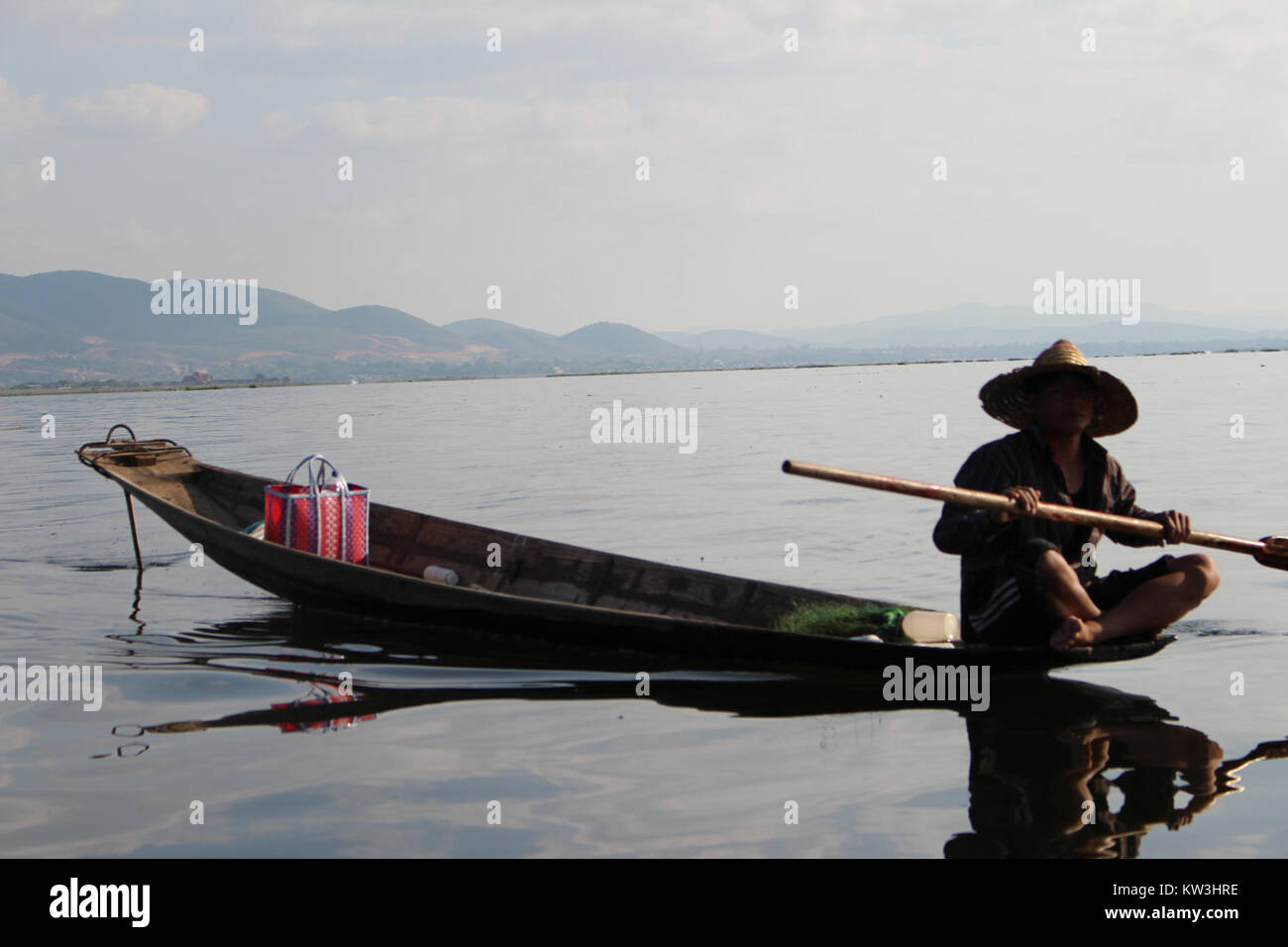 Photograph capturing a boatman navigating the tranquil waters of Inle ...