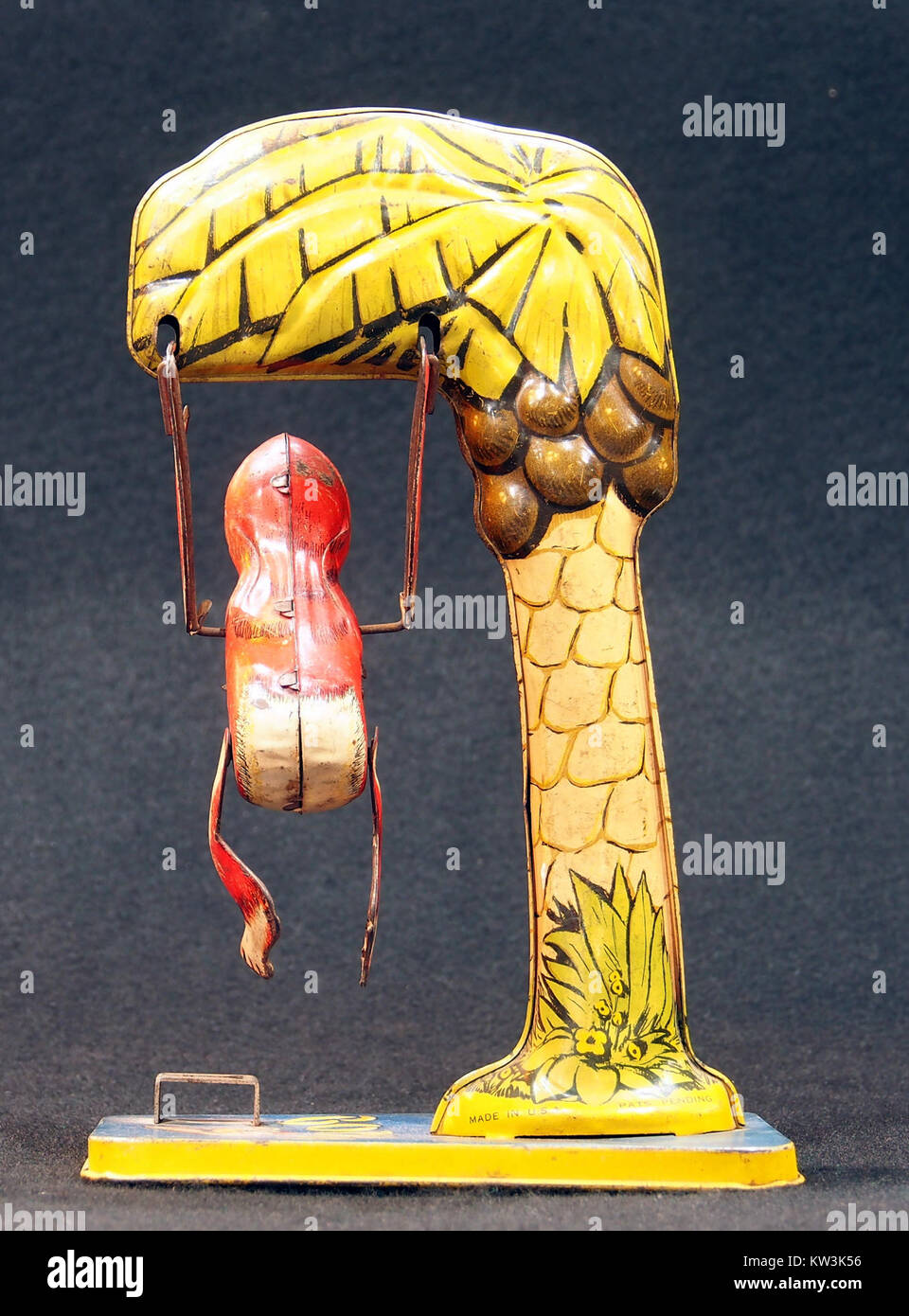 A vintage tin toy monkey in a tree, possibly from the mid-20th century ...