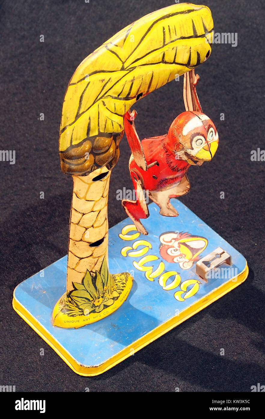 Bombo is a vintage tin toy monkey depicted in a tree. It represents a ...