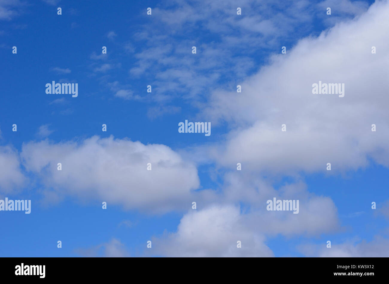 This image features a clear blue sky with scattered white clouds ...
