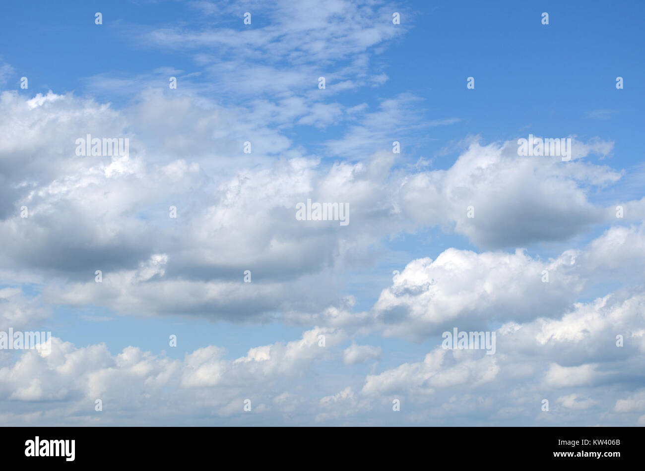 The image captures a clear blue sky with scattered white clouds ...