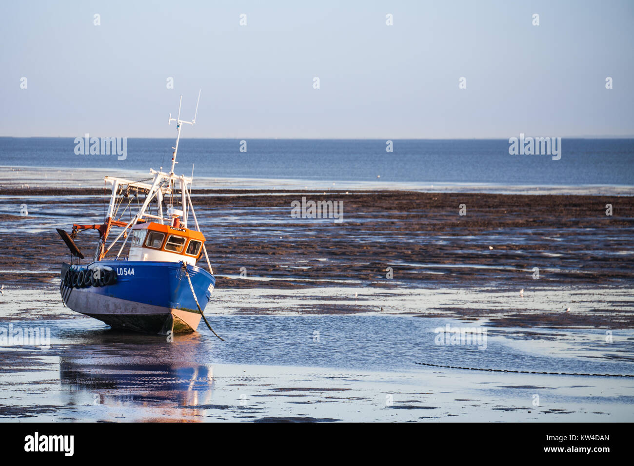 Single boat on beach when the tide is out Stock Photo - Alamy
