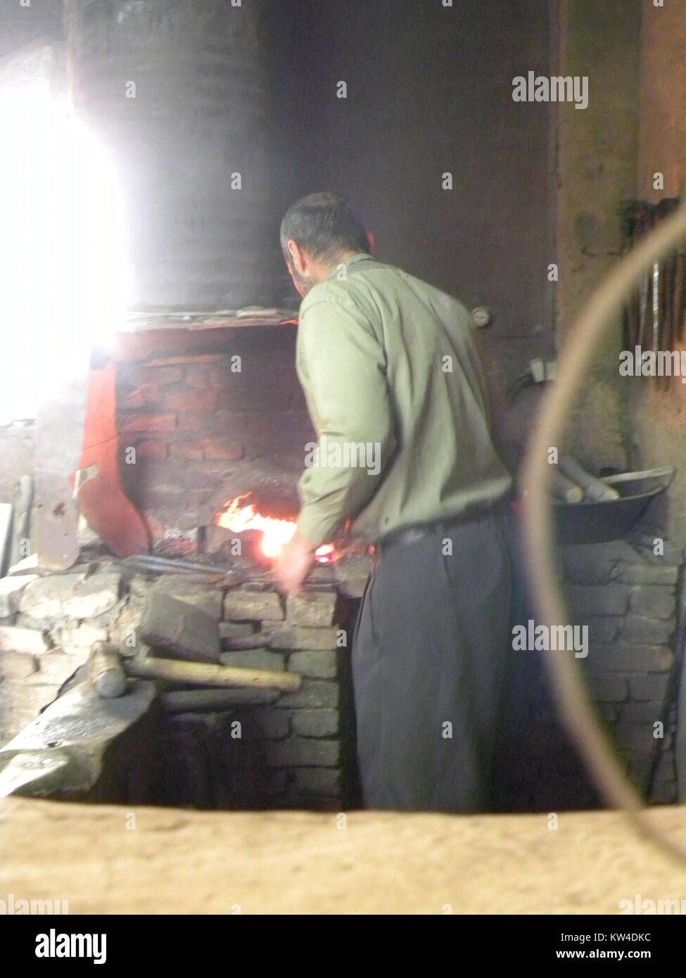 This image depicts a blacksmith at work in Nishapur, an ancient city in ...