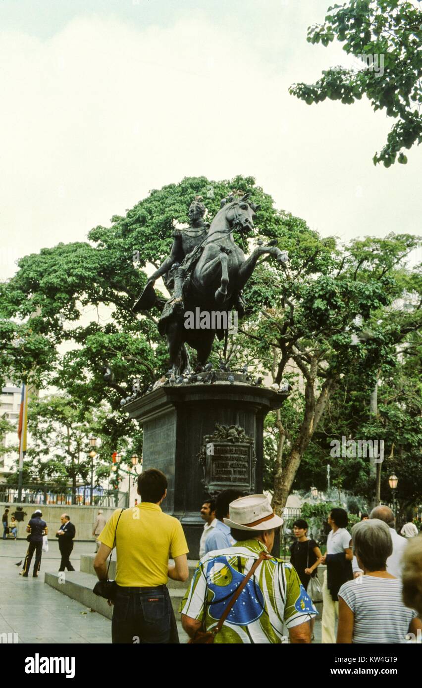 Tourists gather around a statue of Simon Bolivar, Caracas, Venezuela ...