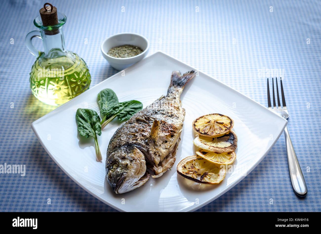 Grilled dorada fish with lemon and spinach Stock Photo - Alamy