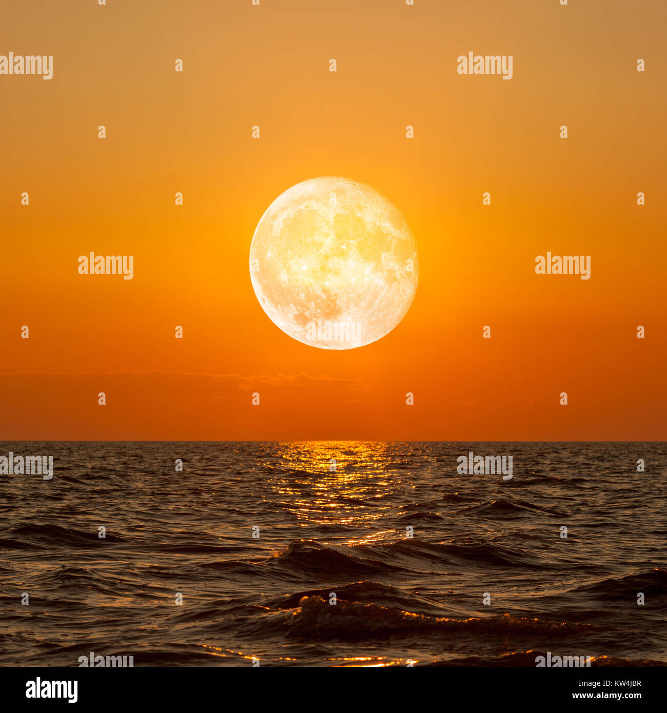 Full moon rising over empty ocean at night Stock Photo - Alamy