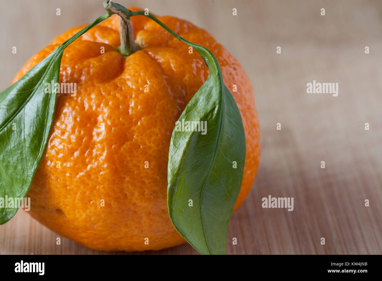 Single mandarin on wooden ledge, close up Stock Photo - Alamy