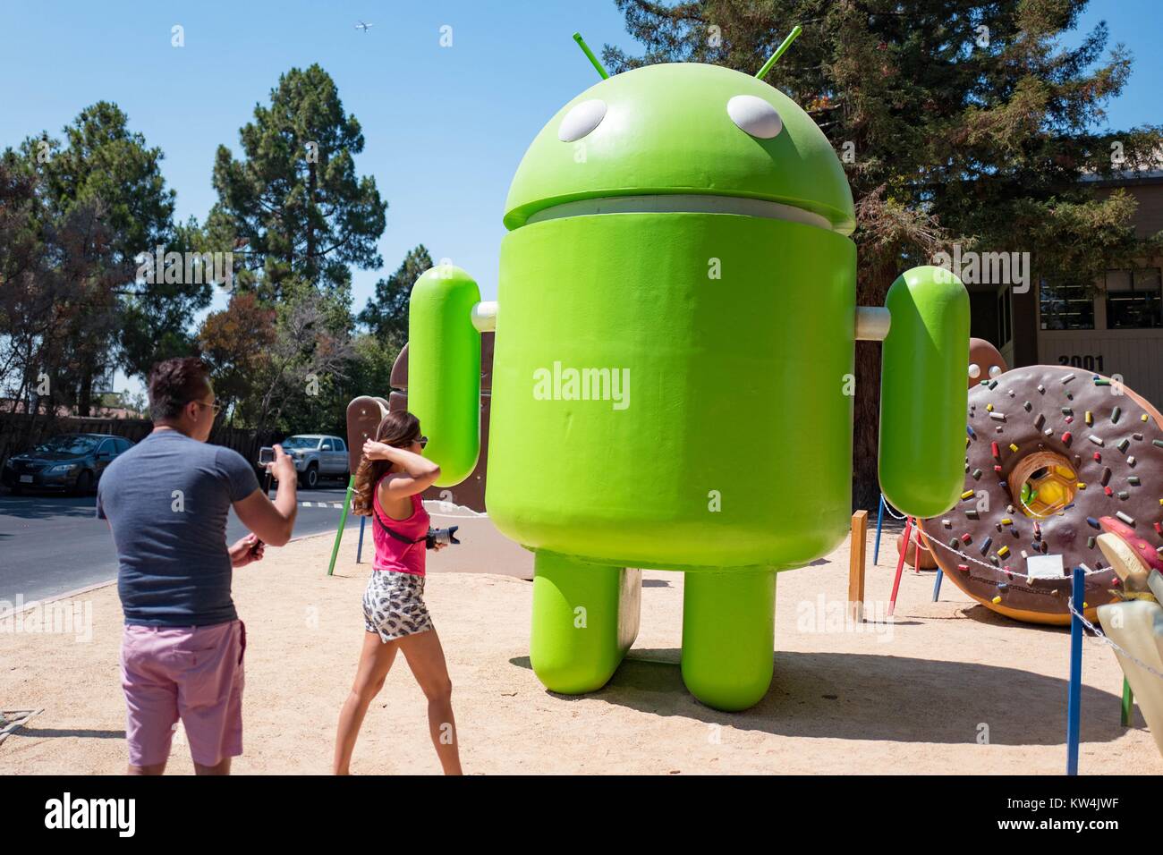 Two tourists prepare to take photographs in front of a large statue ...