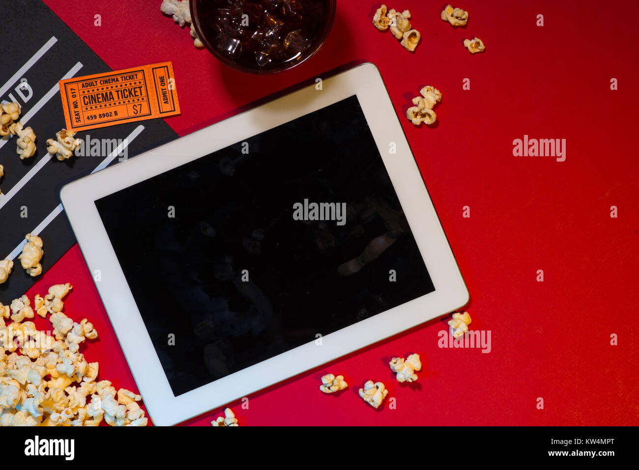 Cinema concept. Digital tablet screen with clapperboard, ticket and ...
