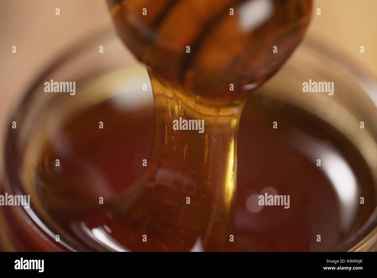 pouring organic honey from dipper into glass jar, shallow focus Stock ...
