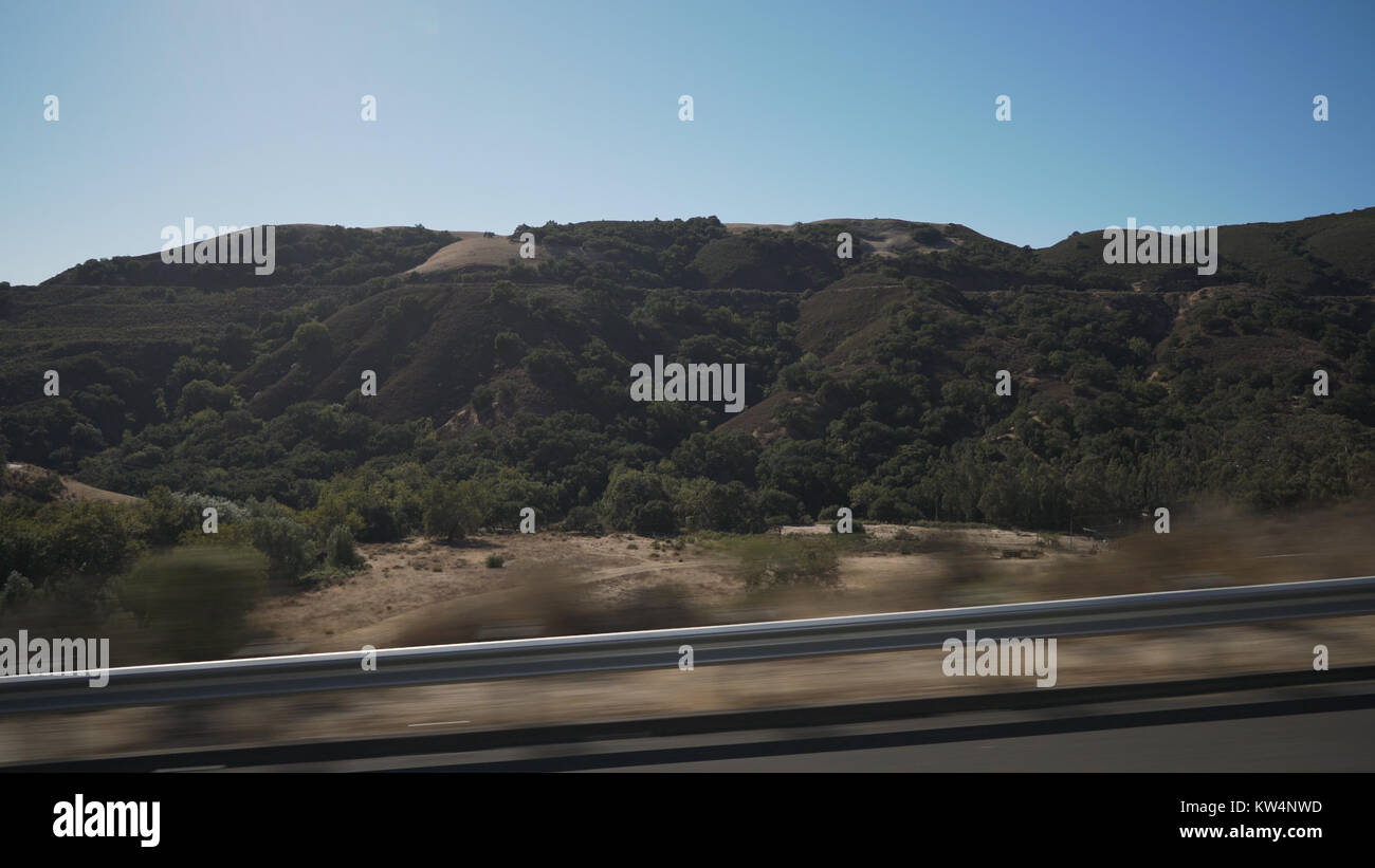 Driving plate side view of forests and hills in California from moving ...