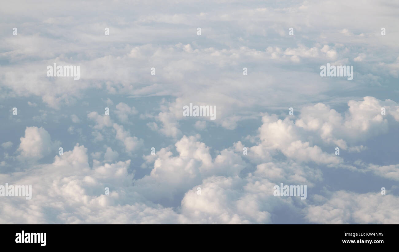 flying above the clouds in daytime view form airplane window, wide ...