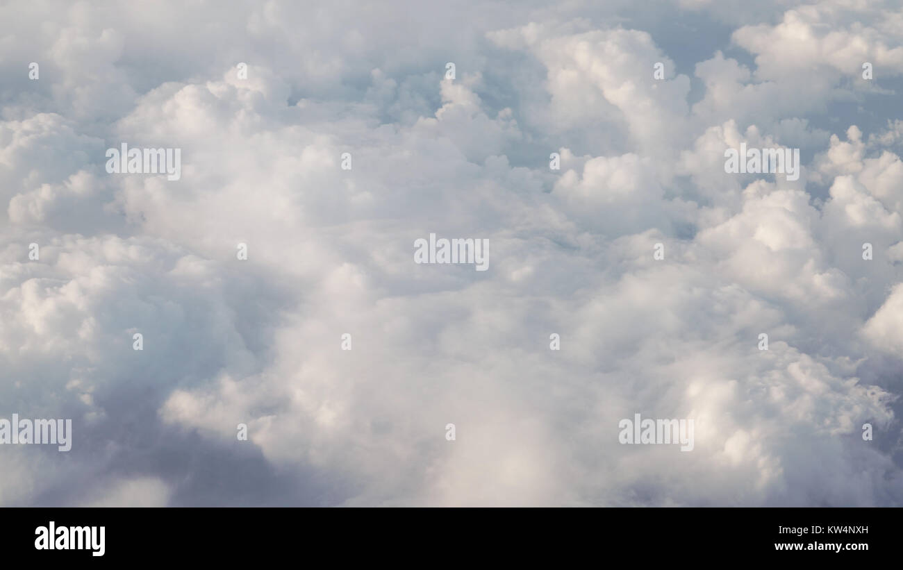 flying above the clouds in daytime view form airplane window, wide ...