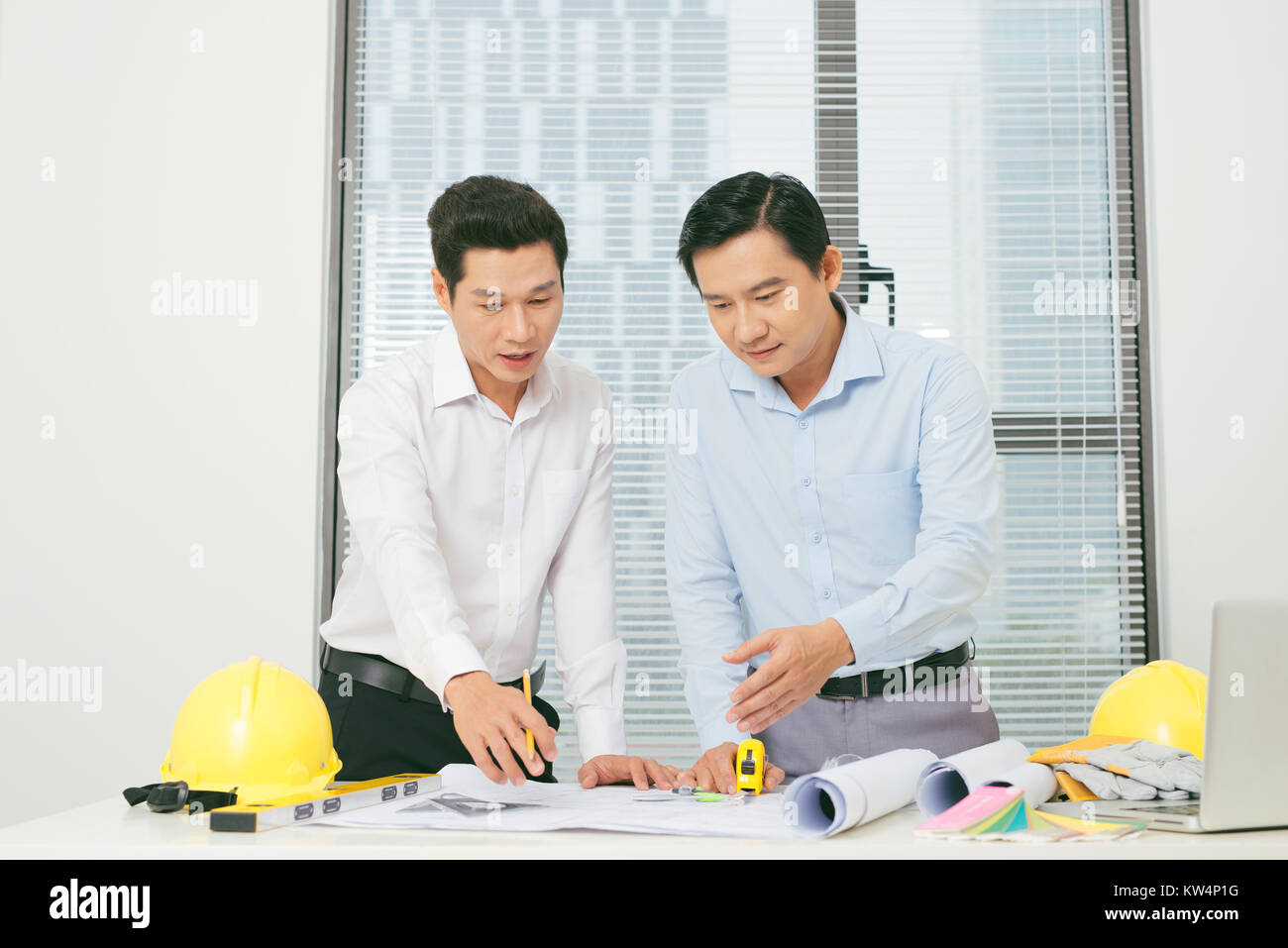 Architects engineer discussing at the table with blueprint of ...