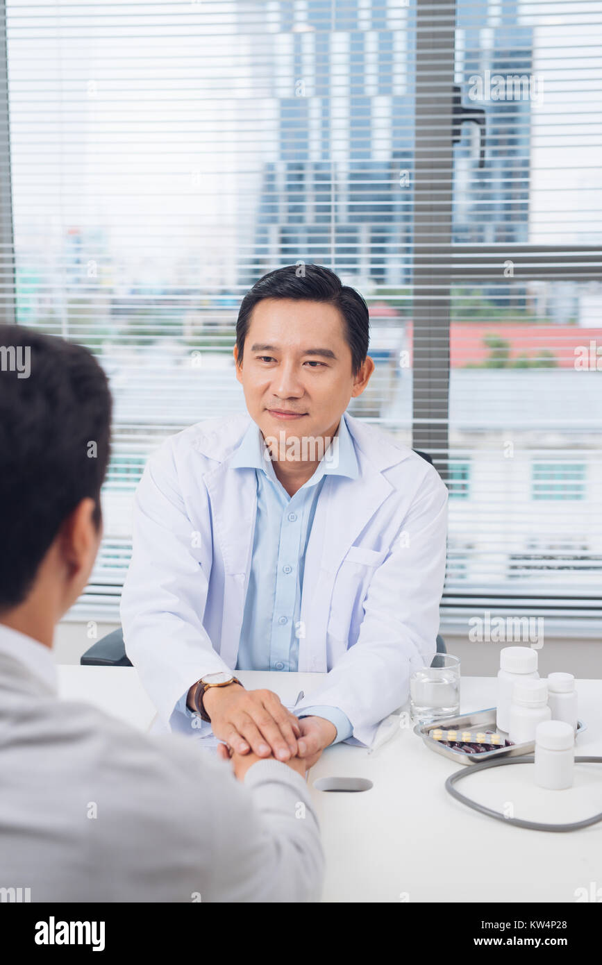 Doctor comforting patient hi-res stock photography and images - Alamy
