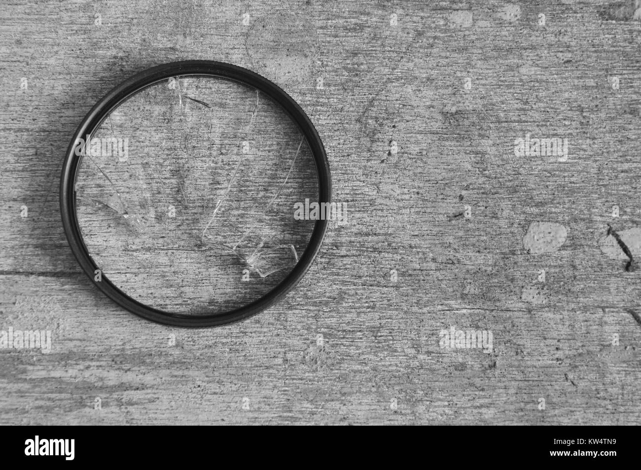 broken camera filter on wooden board Stock Photo - Alamy