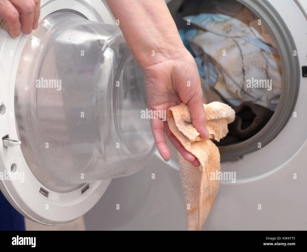 Open door of the washing machine and female hand with clean or dirty ...