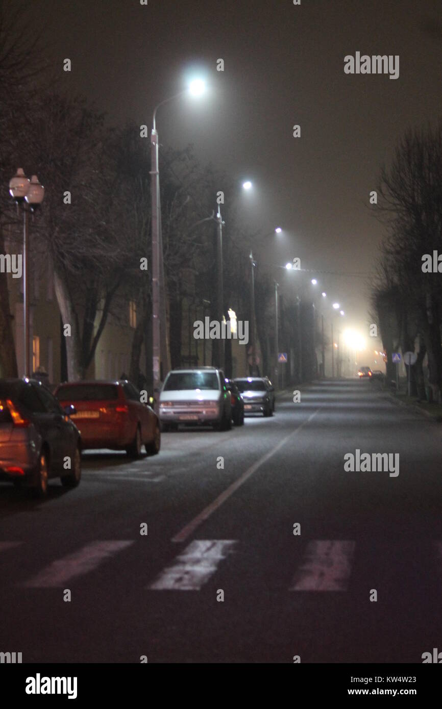 gray dark night city streets with bright shine lanterns in cold winter ...