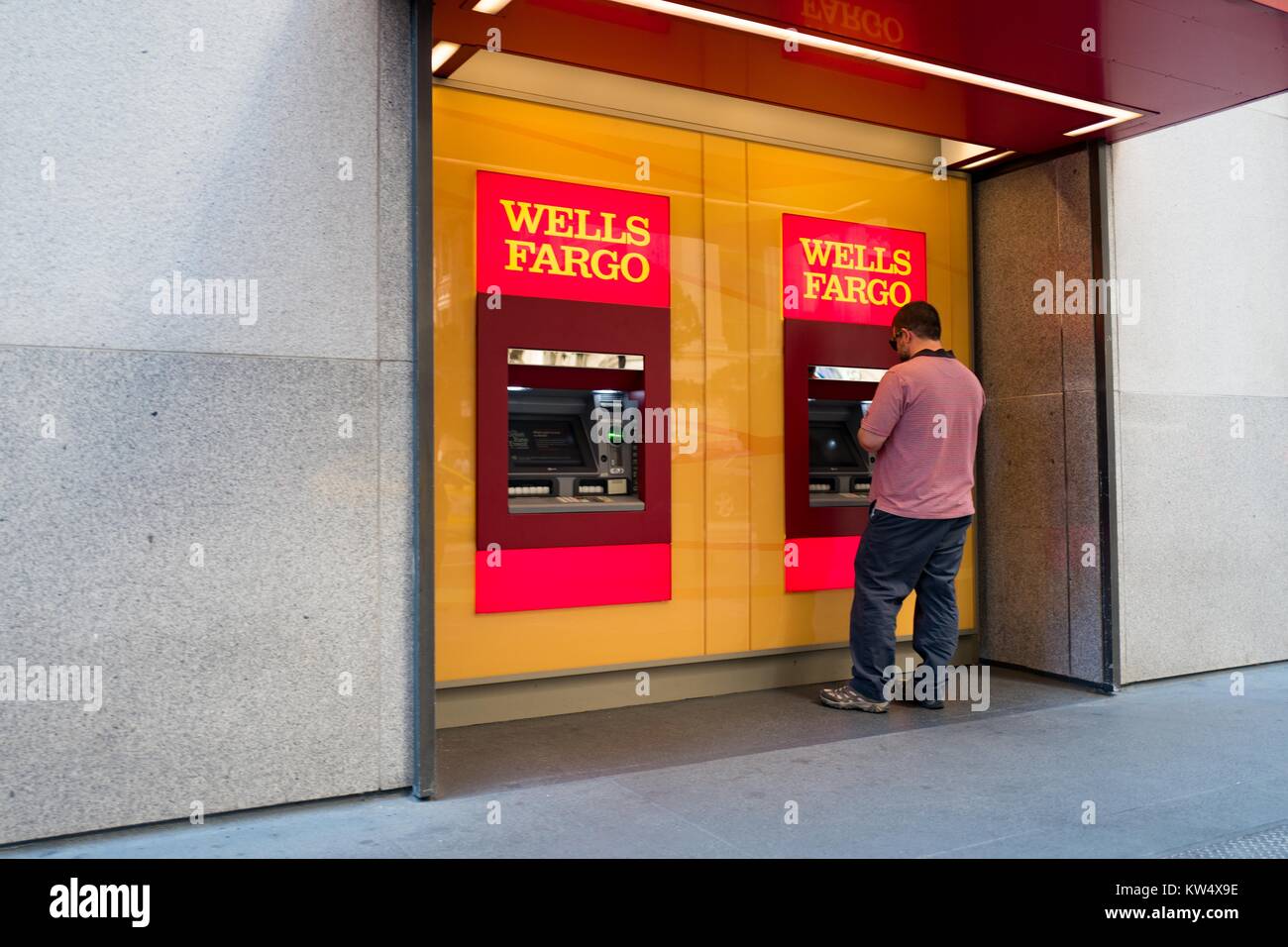 A man uses a Wells Fargo Automated Teller Machine (ATM) outside ...