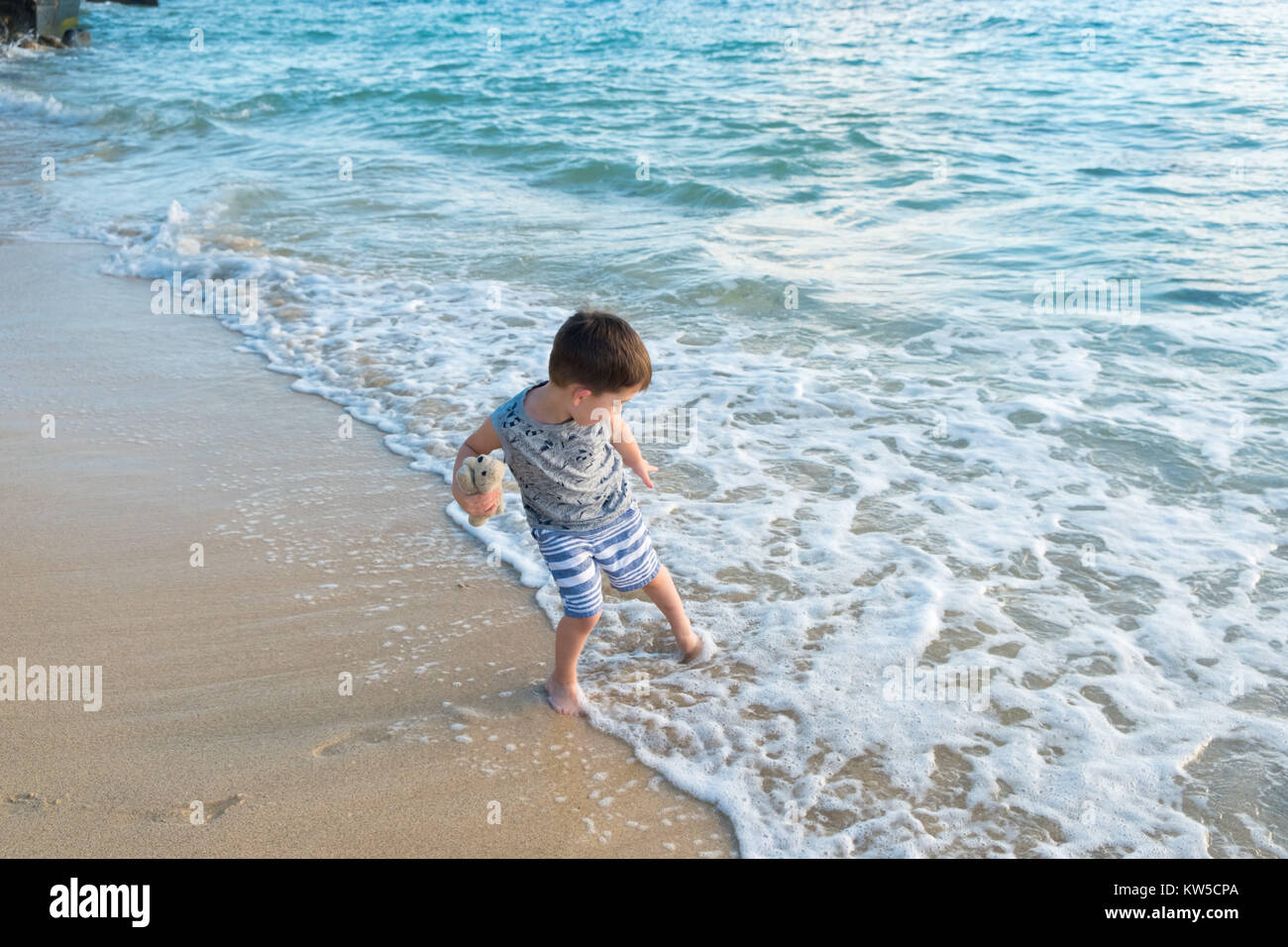 Five year old boy playing in the waves of the Pacific Ocean and having ...