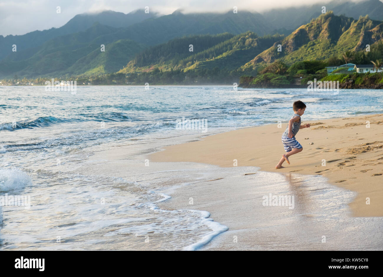 Five year old boy playing in the waves of the Pacific Ocean and having ...