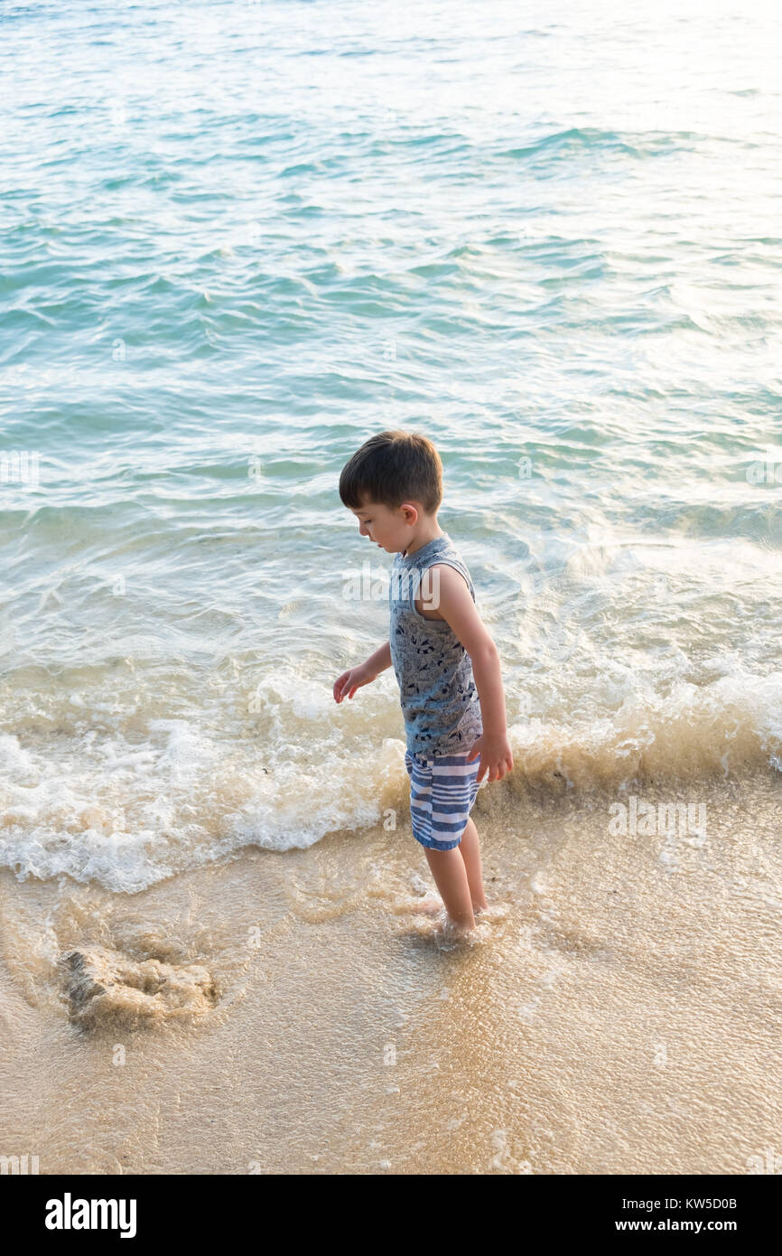 Five year old young boy playing in the water of the Pacific Ocean at ...
