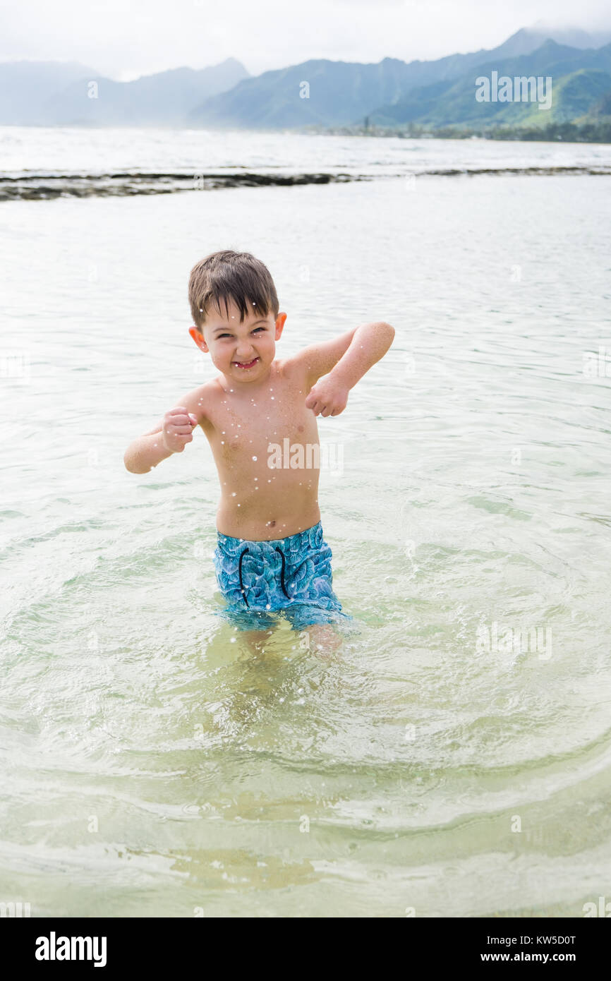 Five year old young boy playing in the water of the Pacific Ocean at ...