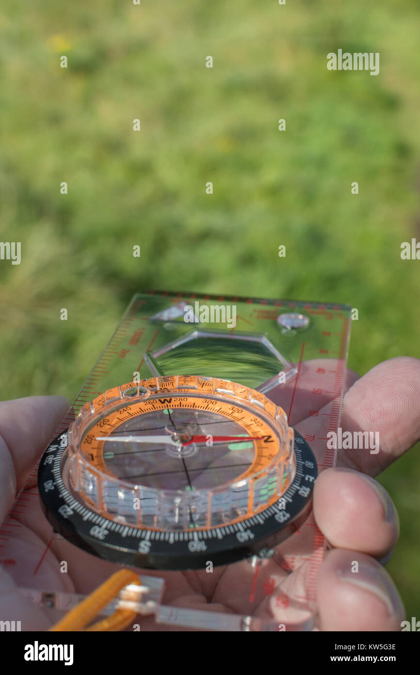 Orienteering compass in hand pointing north. For business 'direction ...