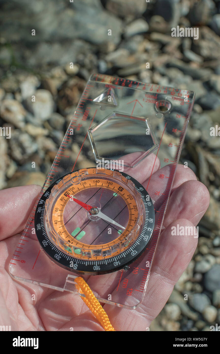 Orienteering compass in hand pointing east. For business direction ...