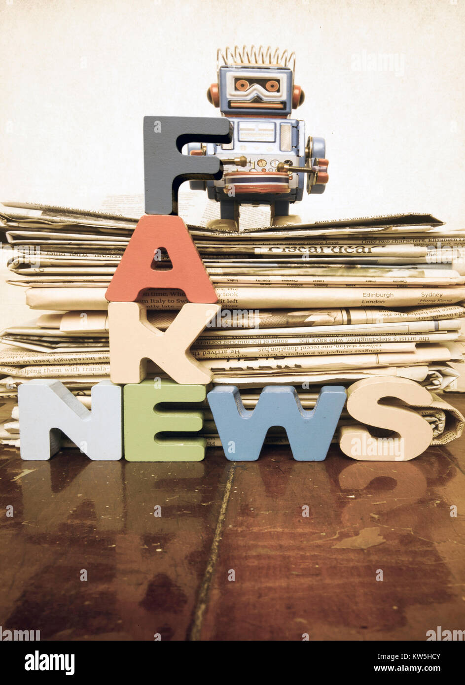 one retro robots a pile of old newspaper with the word FAKE NEWS on a ...