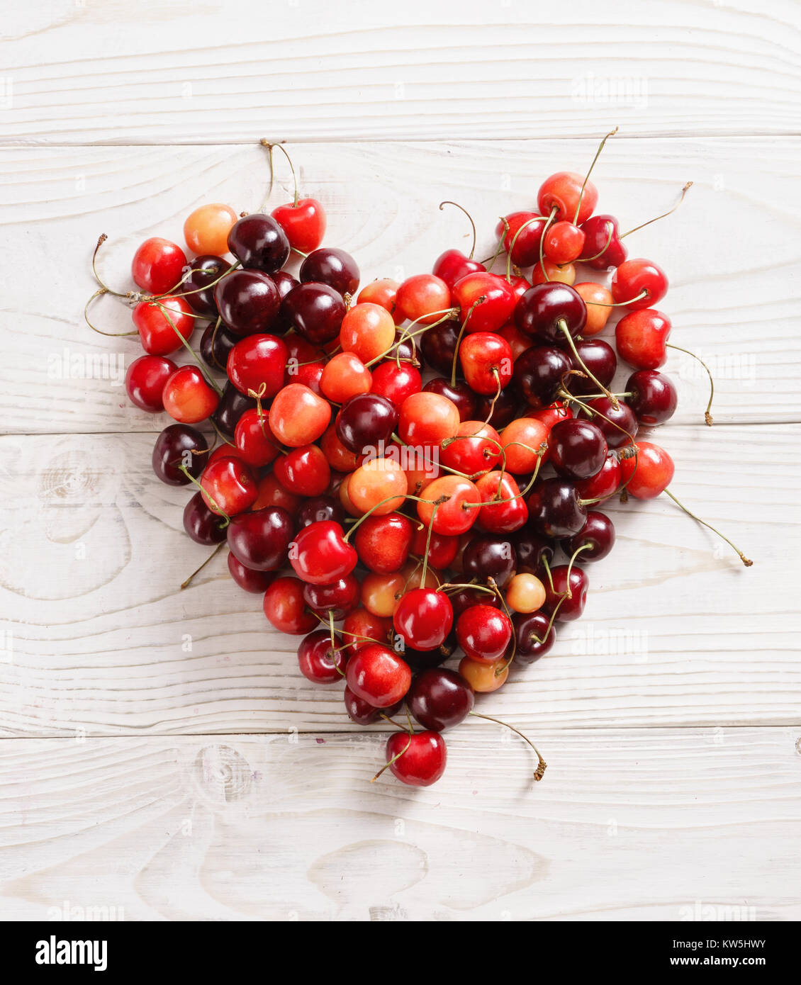Heart made of cherry on white wooden table. Top view. High resolution ...