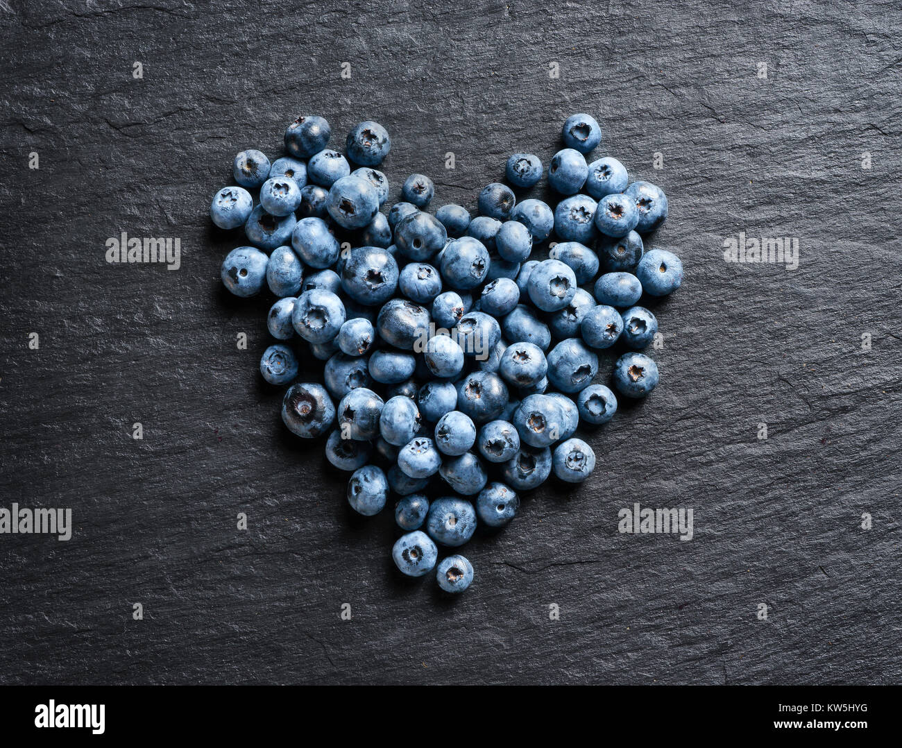 Heart made of blueberry on black slate. Top view. High resolution ...