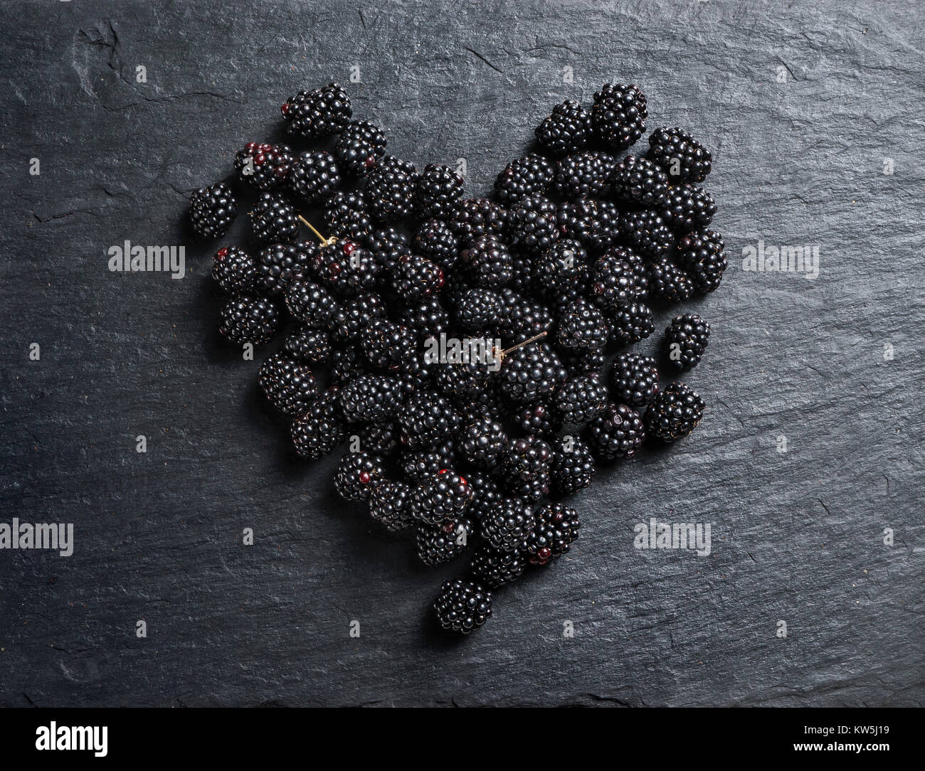 Heart made of blackberry on black slate. Top view. High resolution ...